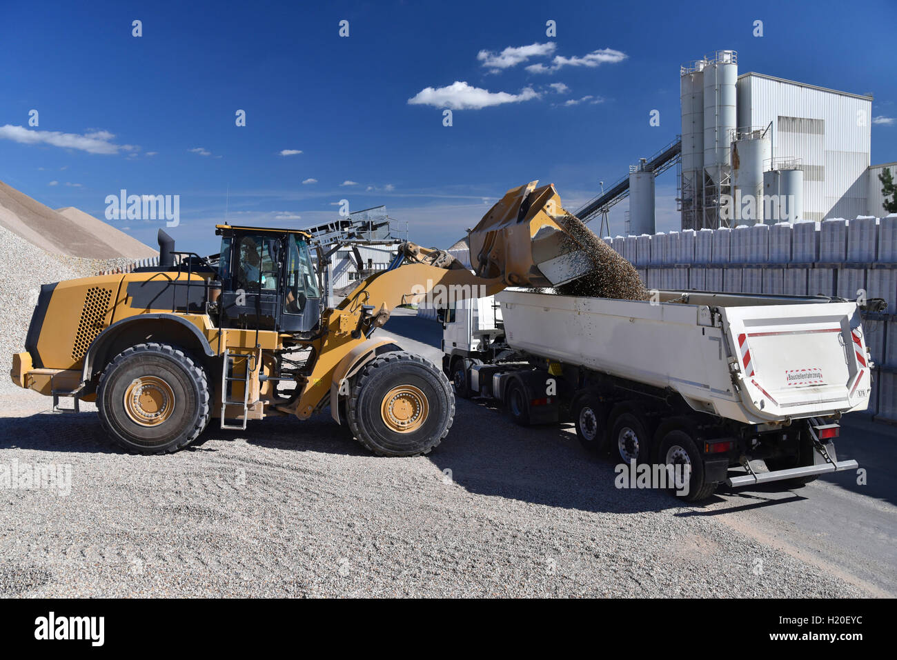 Wheel loader loading gravel on truck Stock Photo - Alamy