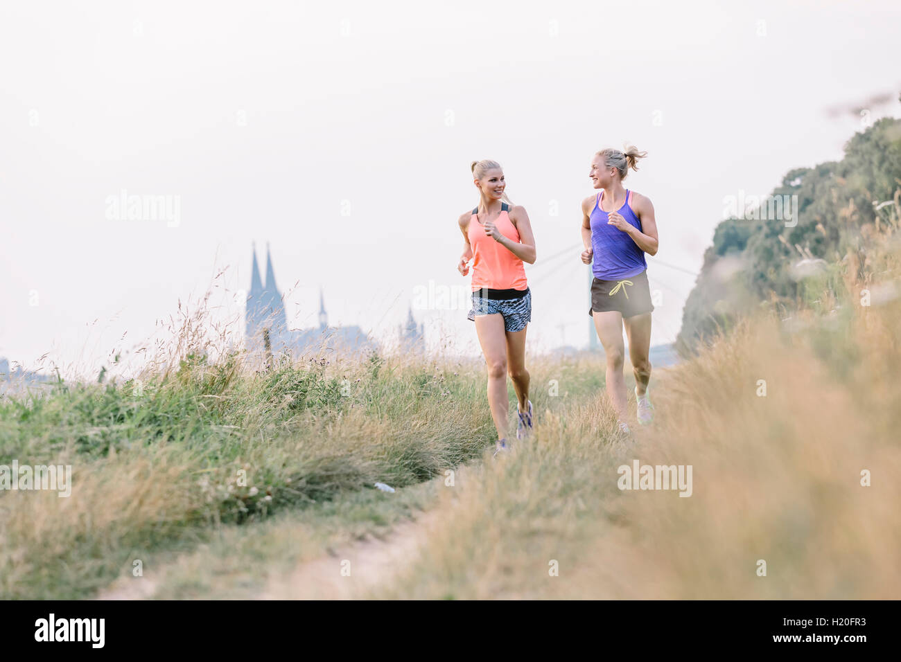Two young women running on field path Stock Photo - Alamy