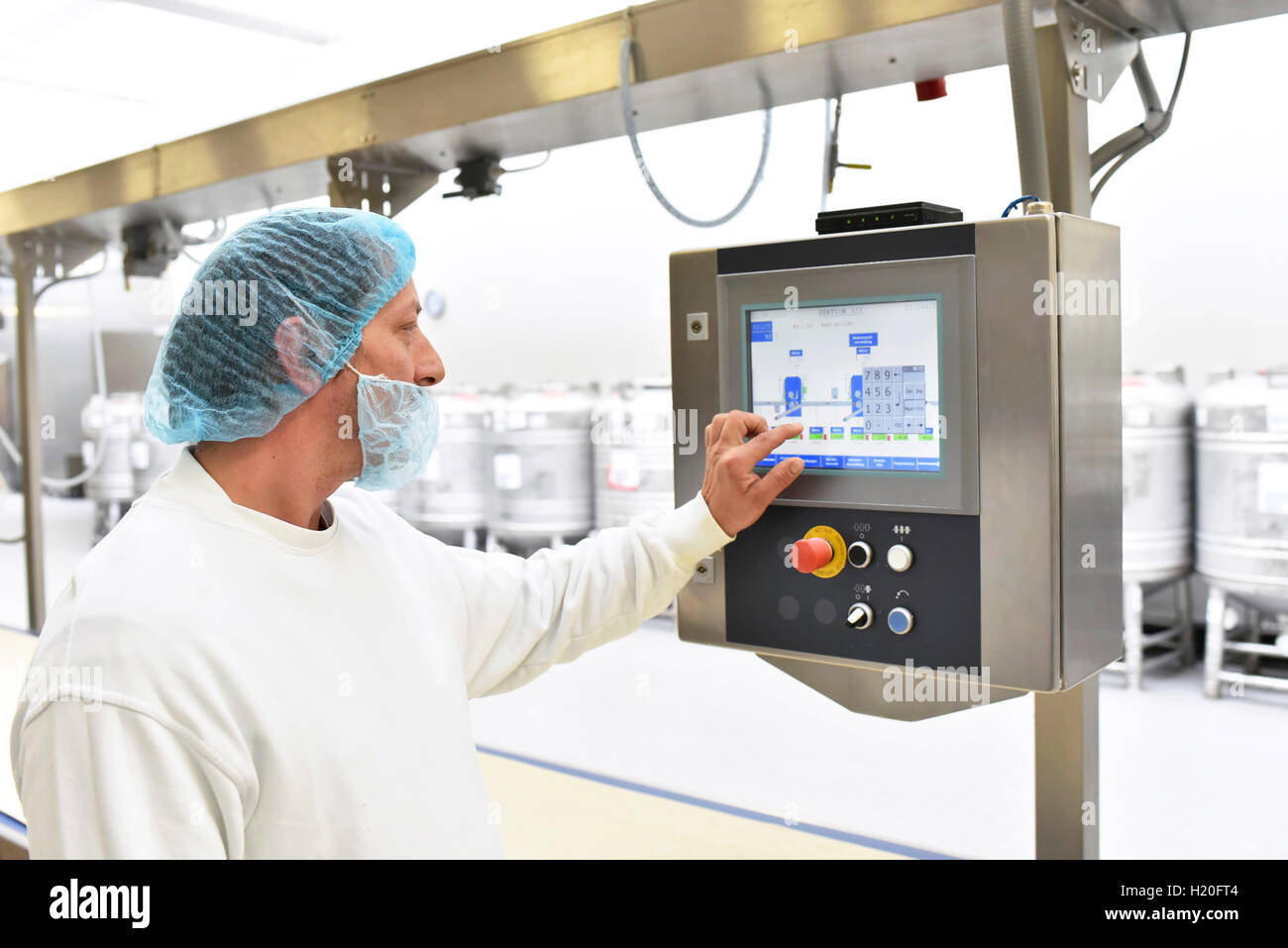 Worker operating machine in an industrial bakery Stock Photo - Alamy