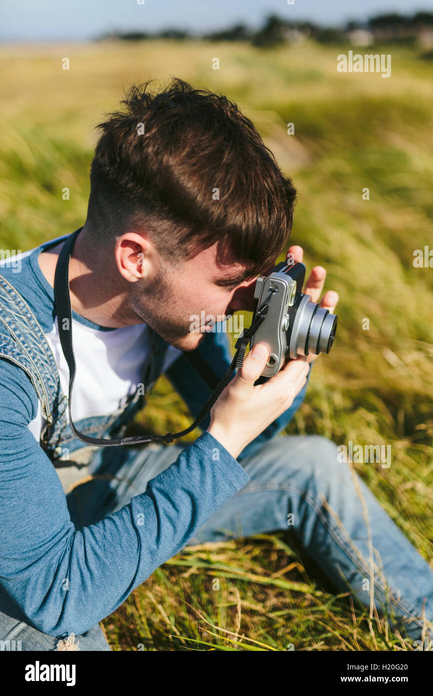 Young man photographing with camera Stock Photo - Alamy
