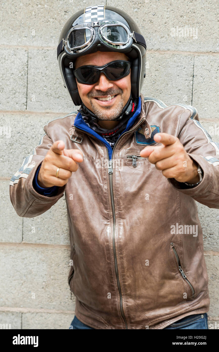 Smiling biker wearing sunglasses and helmet pointing on viewer Stock ...