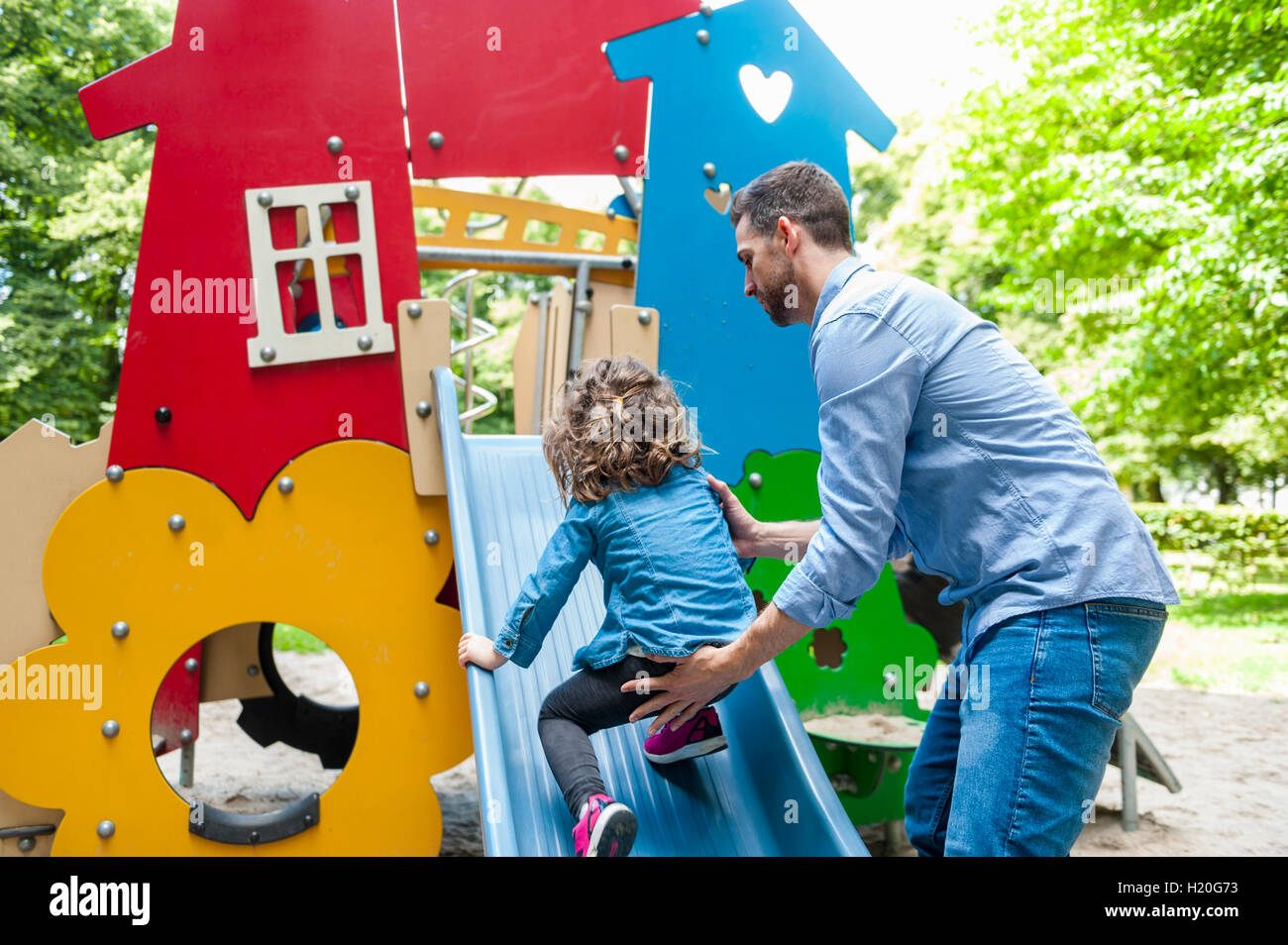 Father with daughter on playground slide Stock Photo - Alamy