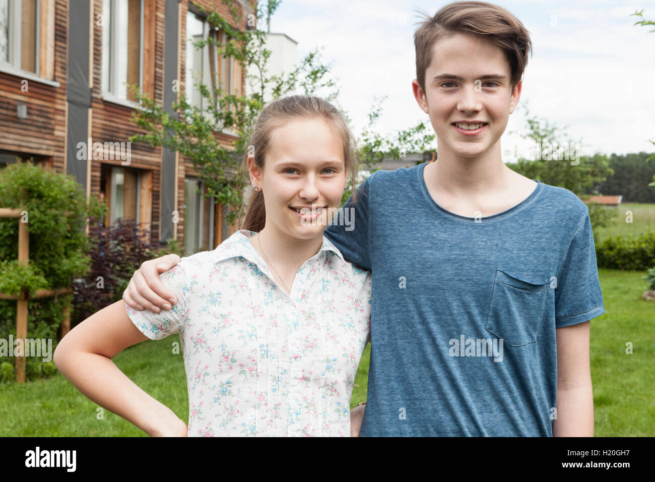 Portrait of smiling siblings in garden Stock Photo - Alamy