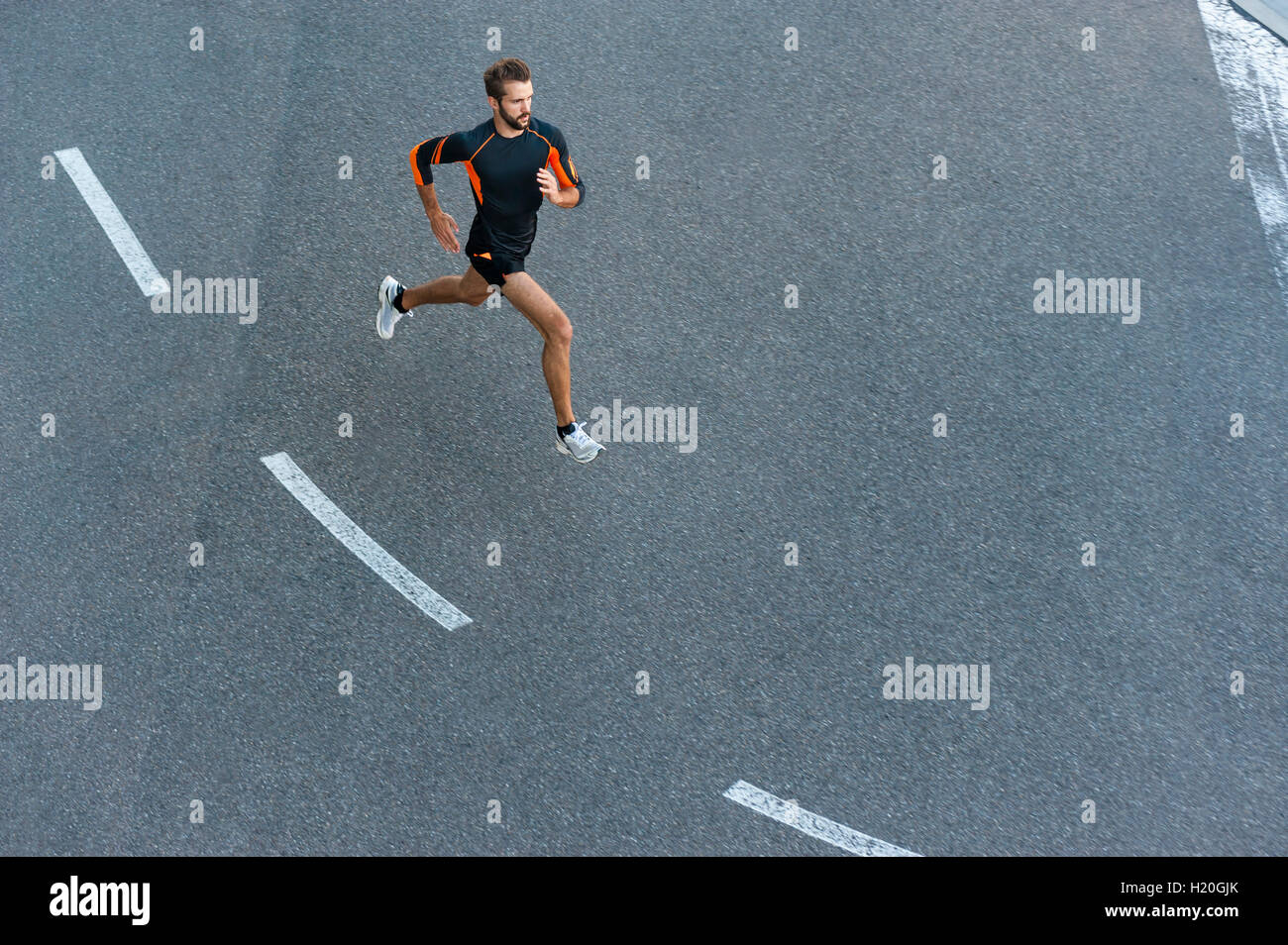 Man running on street with markings Stock Photo - Alamy