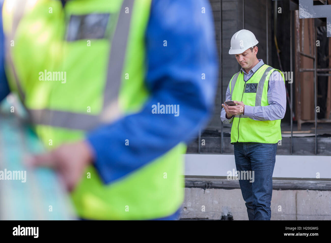 Men with cell phone on construction site Stock Photo - Alamy