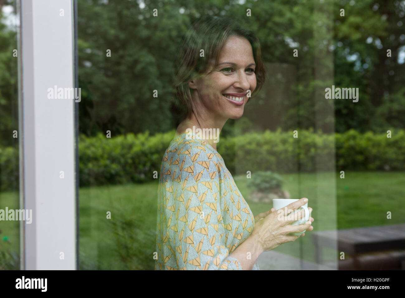 Woman garden window with cup hi-res stock photography and images - Alamy