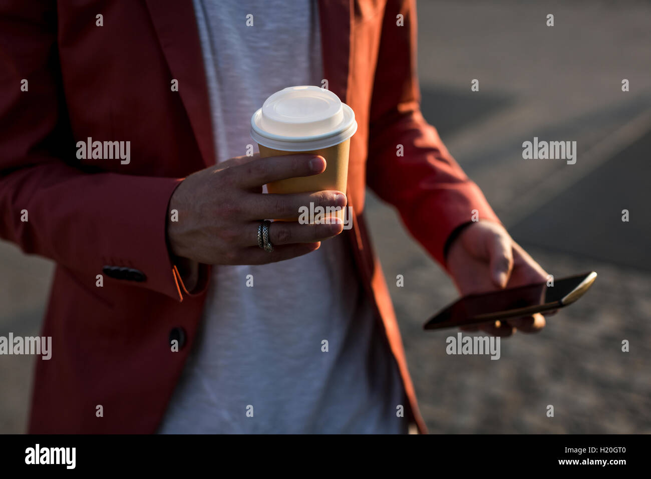 Man's hand holding coffee to go Stock Photo - Alamy