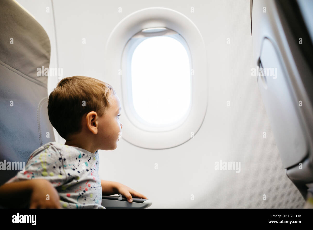 Little boy looking out of window while flying on an airplane Stock ...