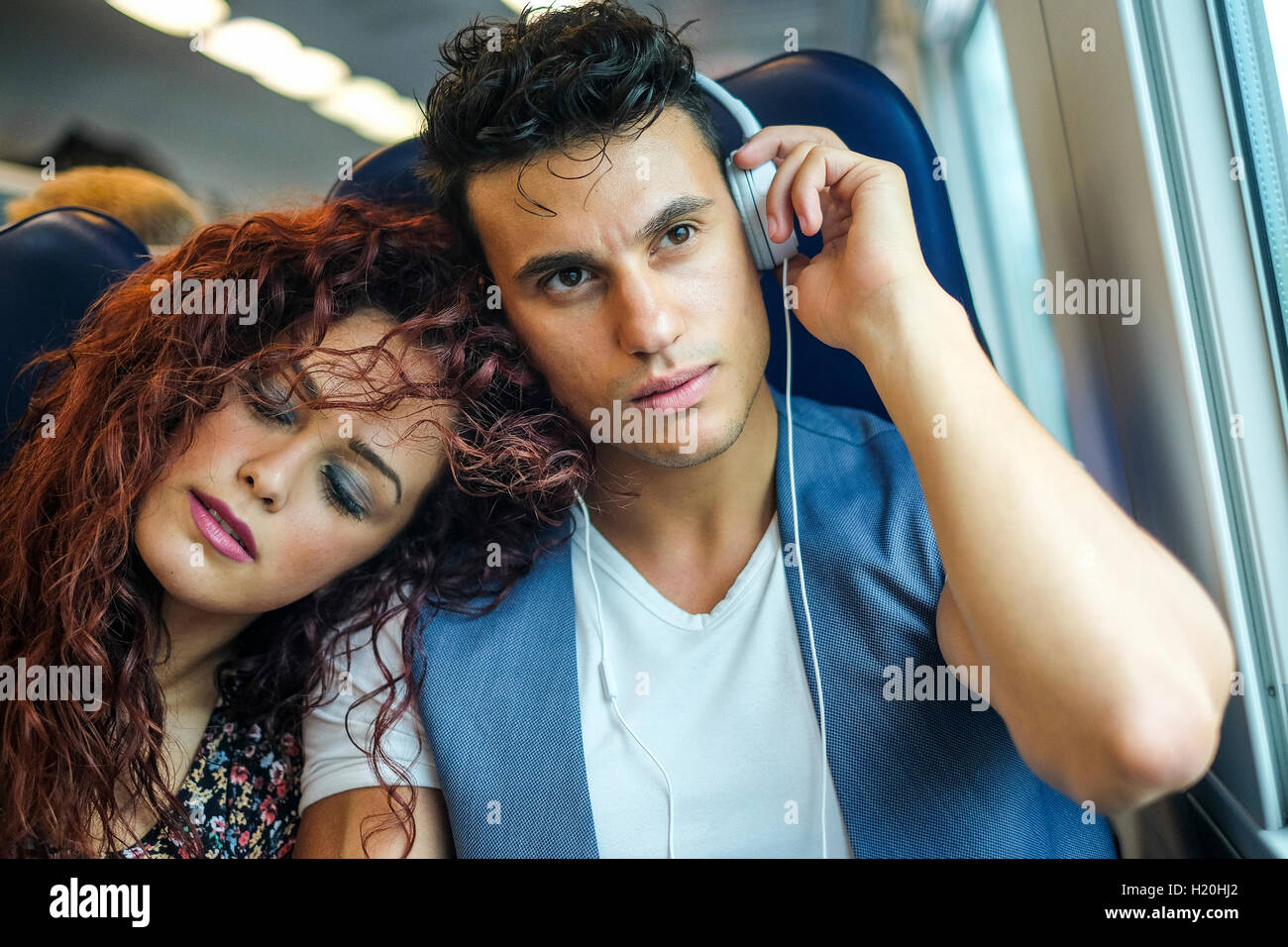 Portrait of relaxed young couple in a train Stock Photo - Alamy