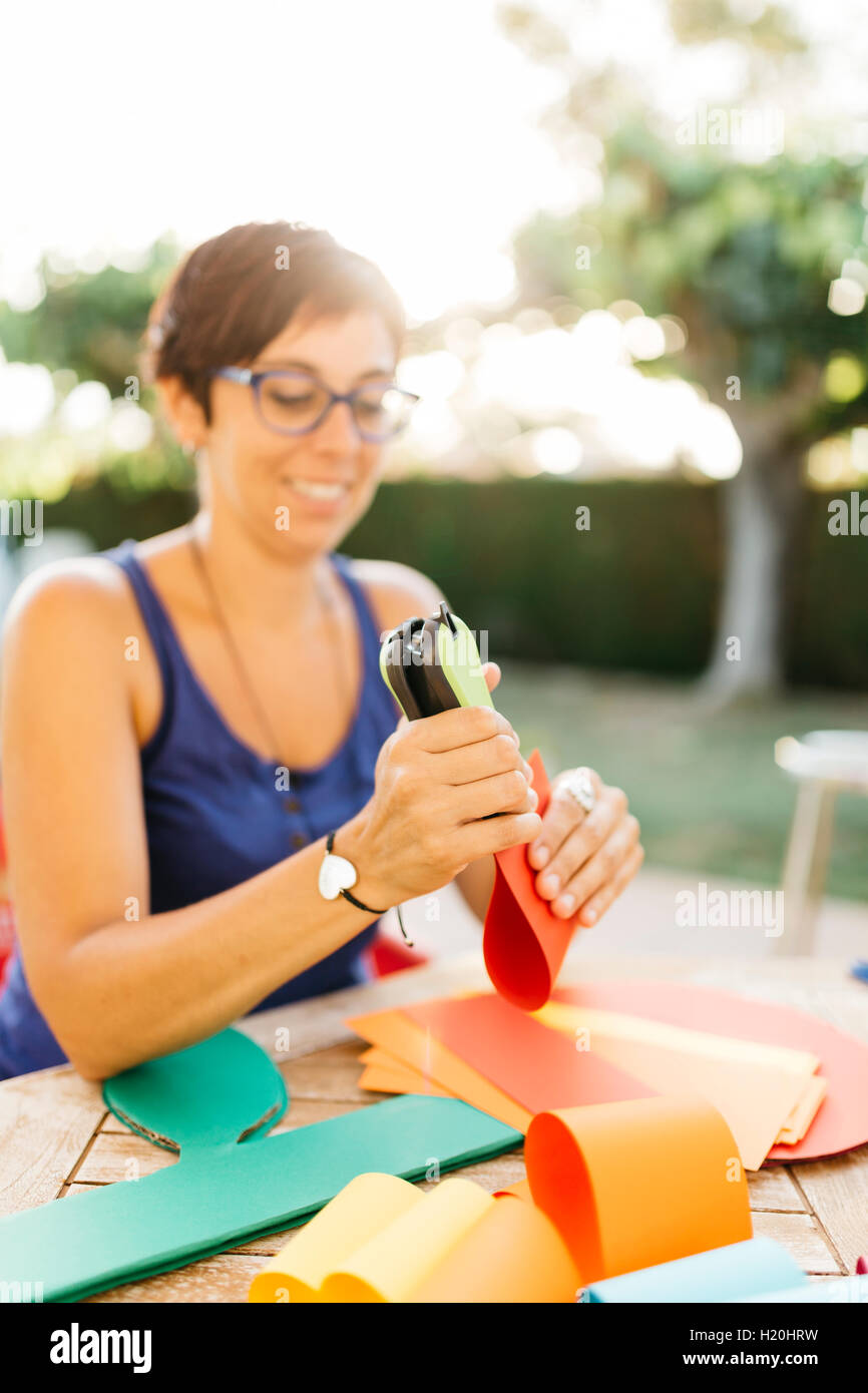 Woman doing handicrafts at garden table Stock Photo - Alamy