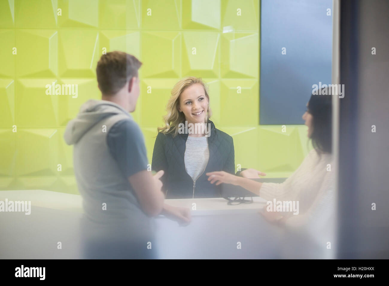 Receptionist talking to clients Stock Photo - Alamy