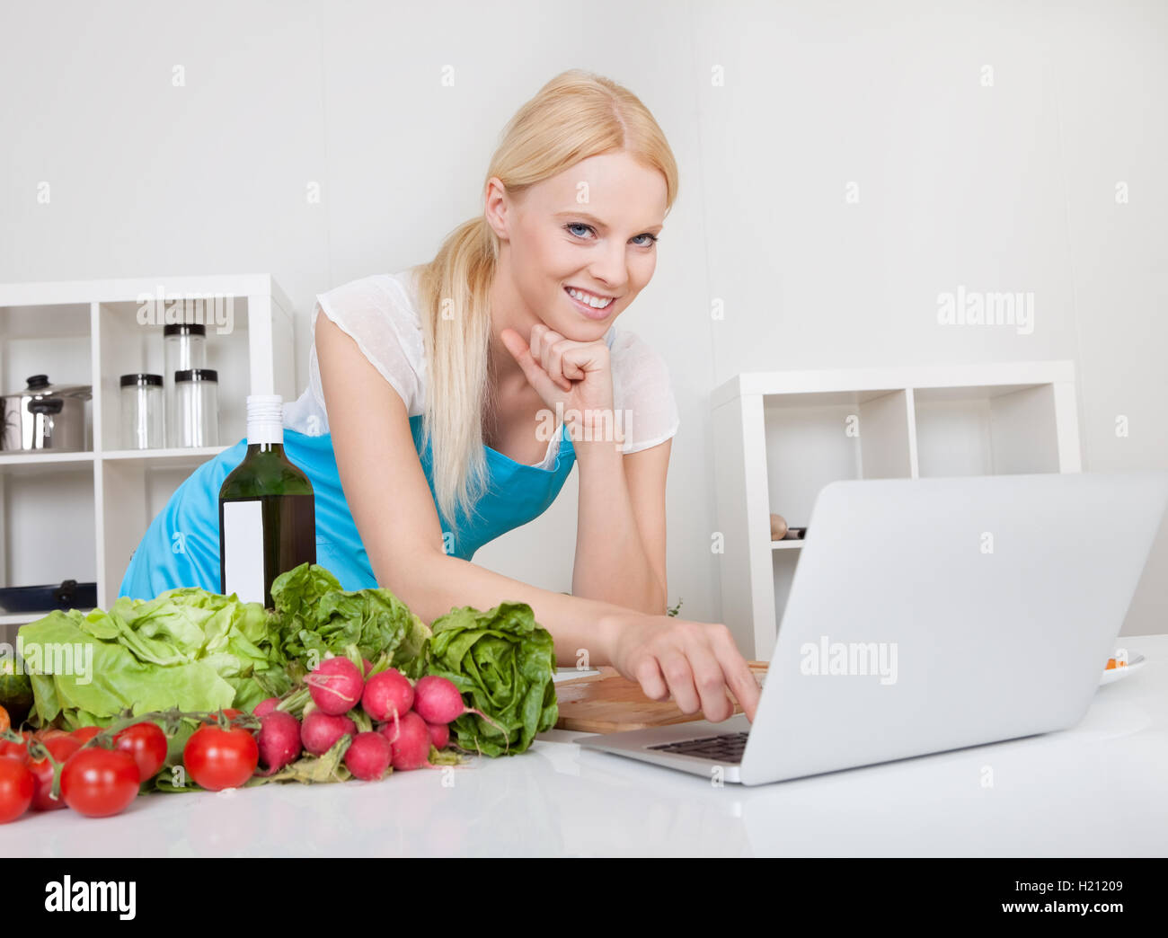 Cheerful young woman cooking Stock Photo - Alamy