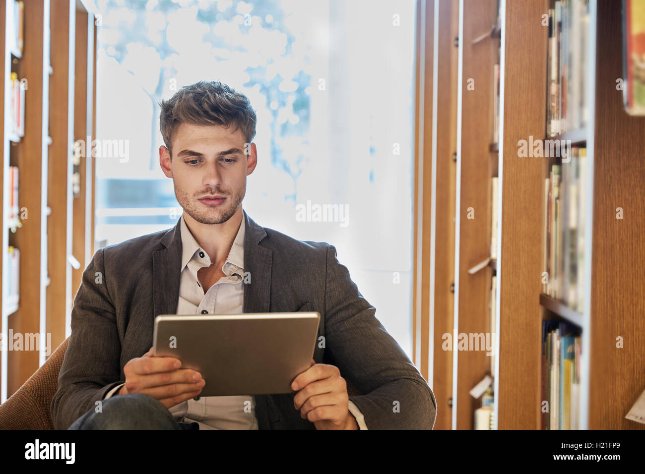 Man using tablet in library hi-res stock photography and images - Alamy