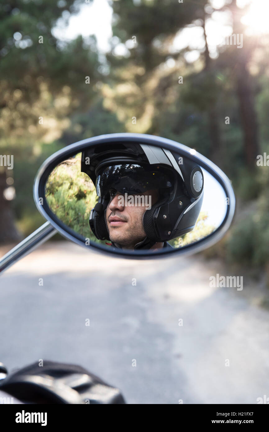 Reflection of man with motorcycle helmet in mirror of motorbike Stock ...