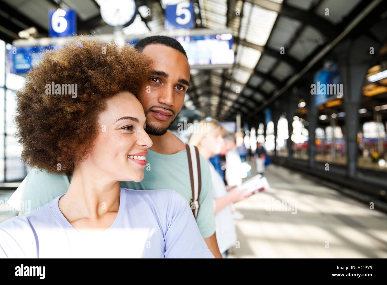 Happy young couple waiting for commuter train Stock Photo - Alamy