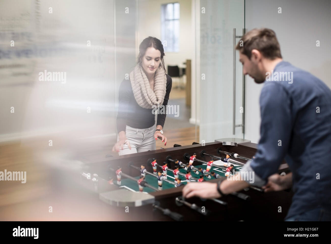 Two colleagues playing foosball in office break room Stock Photo - Alamy