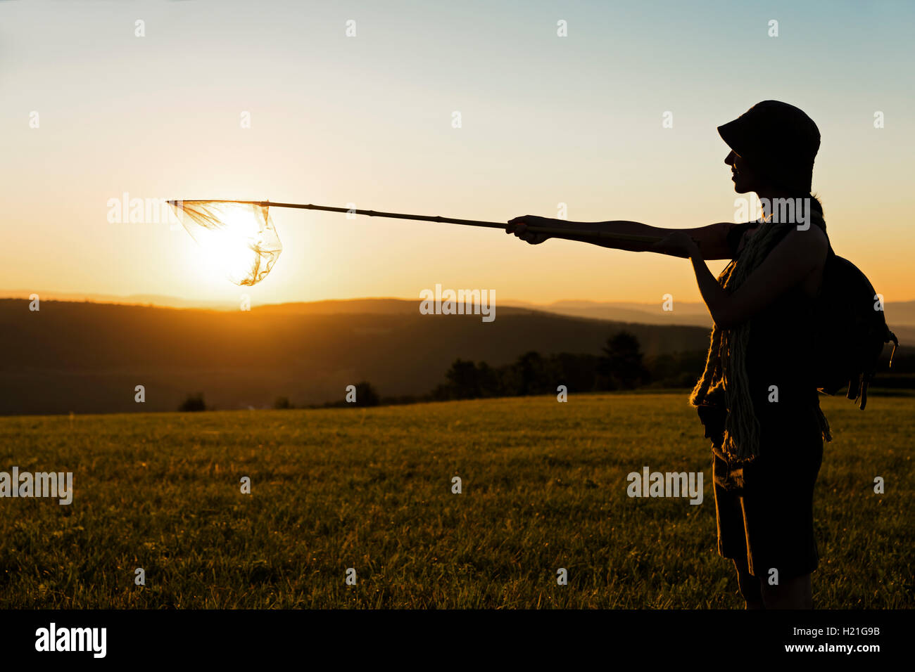 Female hiker catching sun with dip net at dawn Stock Photo - Alamy