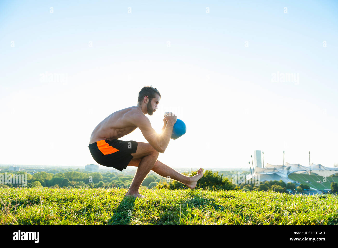 Man exercising with kettlebell on a meadow Stock Photo - Alamy