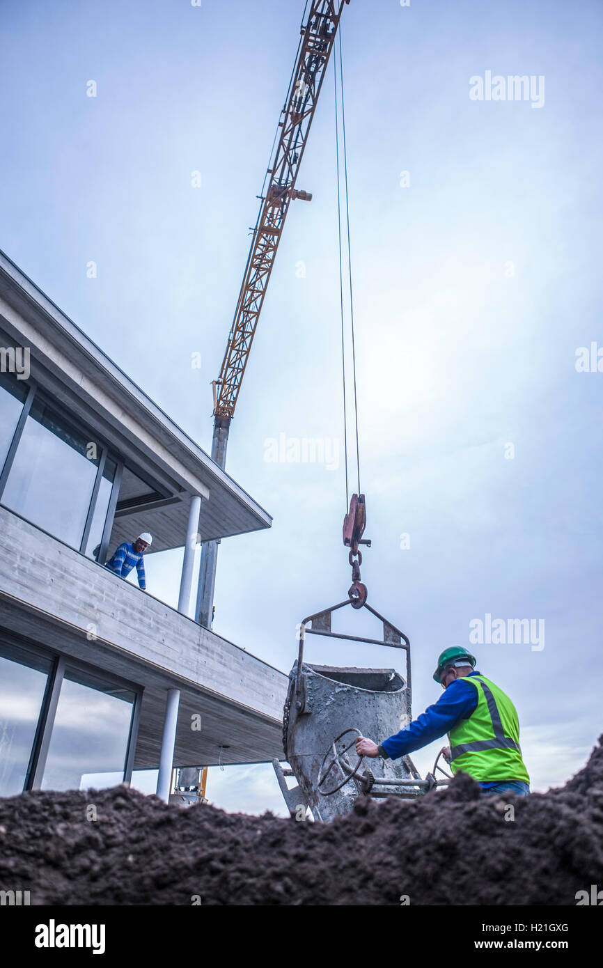 Construction worker on construction site with crane Stock Photo - Alamy