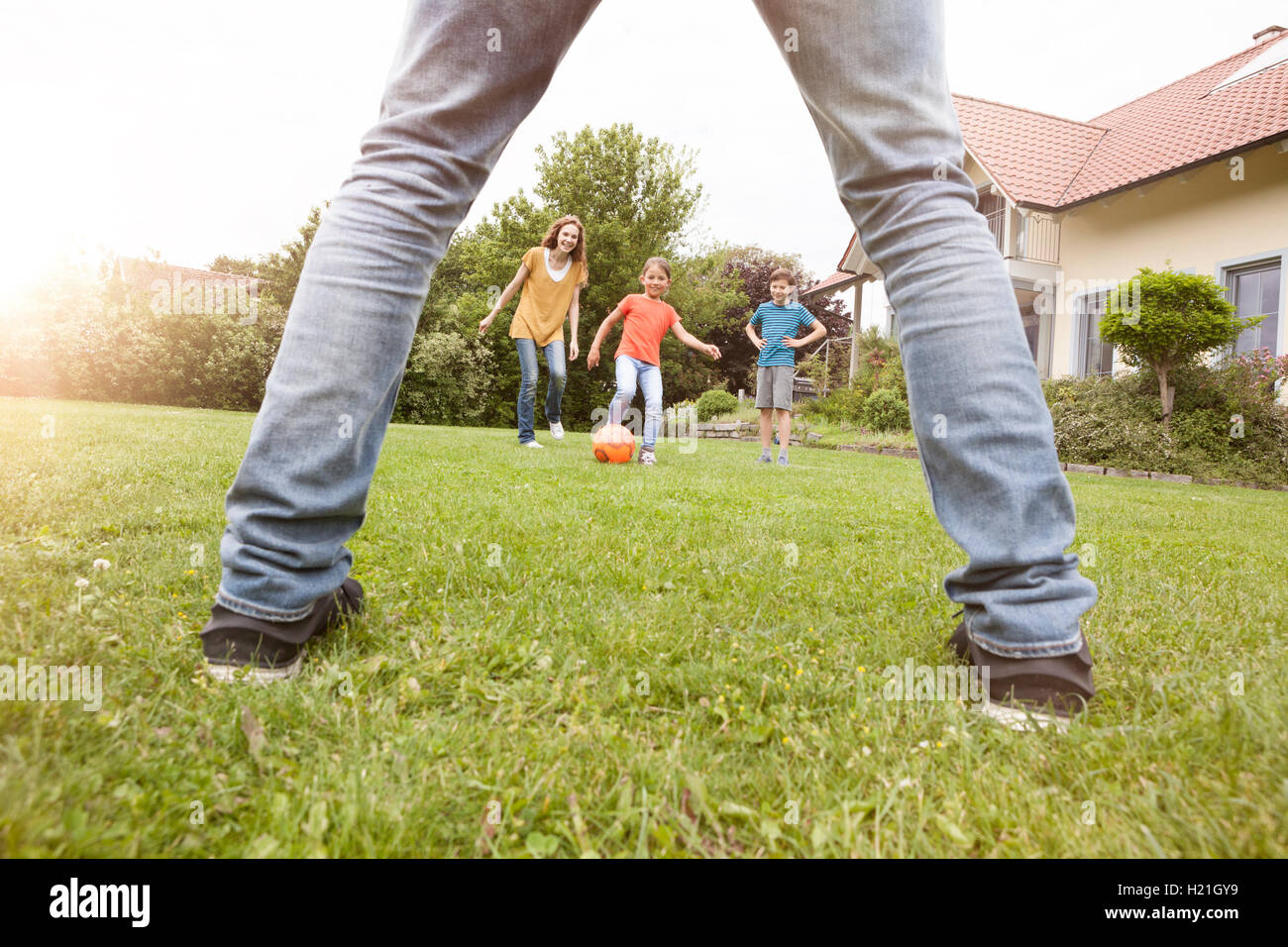 Family playing football in garden Stock Photo - Alamy