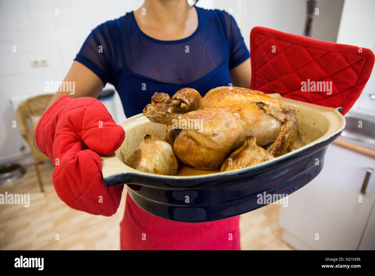 Woman with a roast chicken Stock Photo - Alamy
