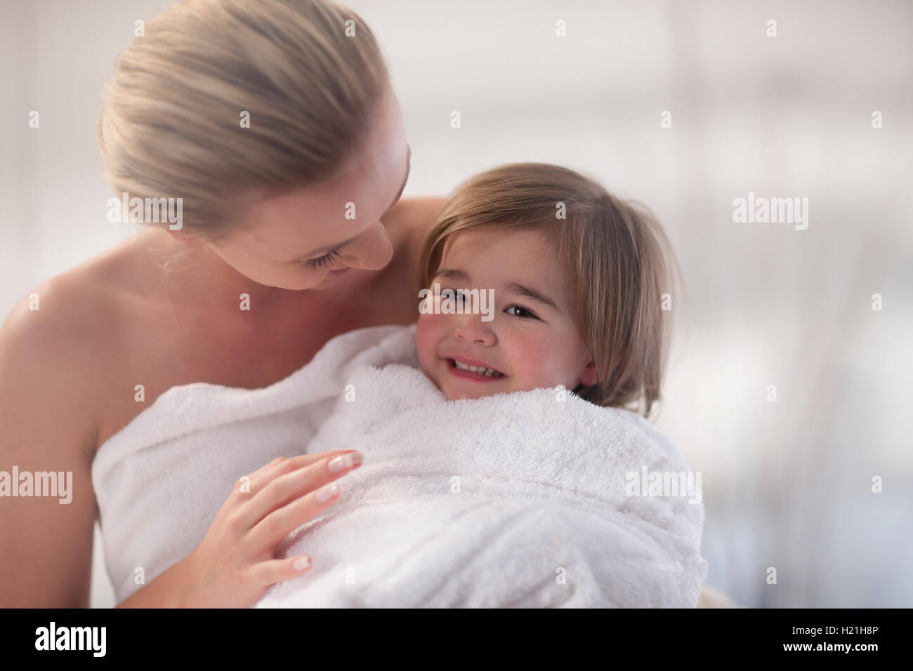 Young woman and little girl wrapped in a towel Stock Photo - Alamy