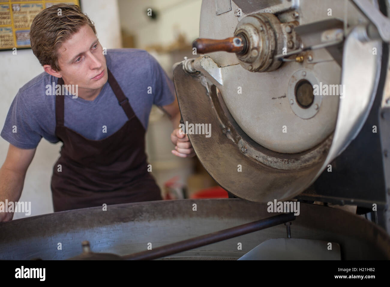 Man standing next to coffee roasting machine Stock Photo - Alamy