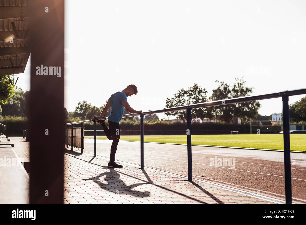 Athlete stretching in a track and field stadium Stock Photo - Alamy