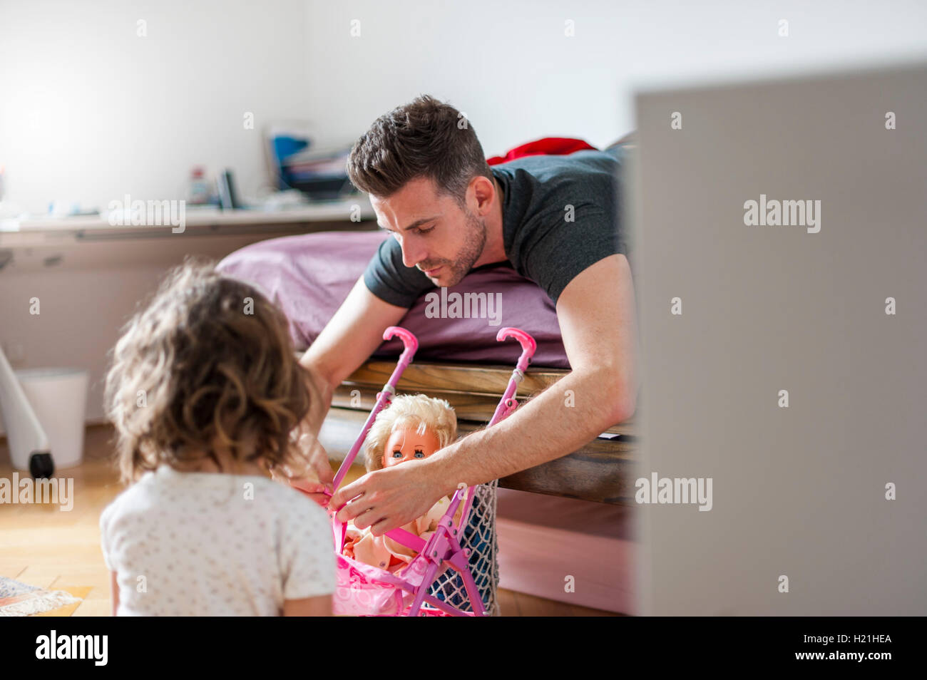 Father and daughter with doll in bedroom Stock Photo - Alamy