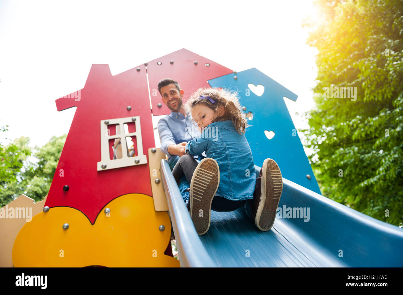 Father with daughter on playground slide Stock Photo - Alamy