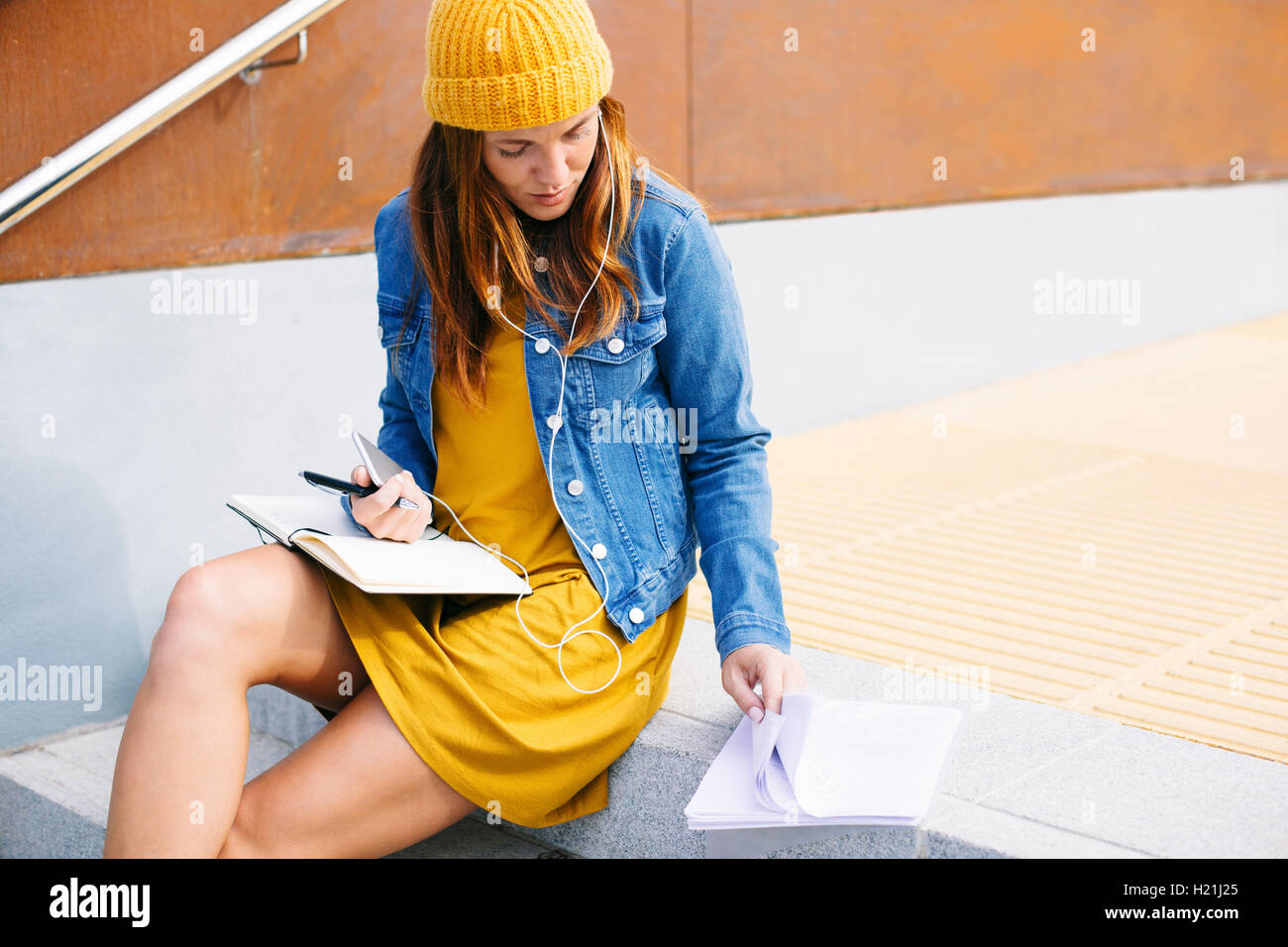 Young woman with notebook sitting on steps Stock Photo - Alamy
