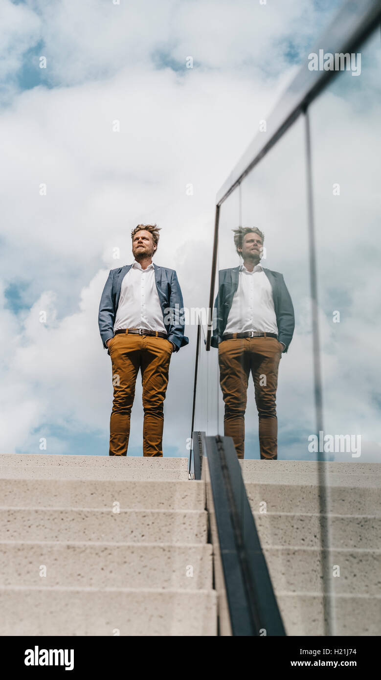 Businessman standing atop of stairs Stock Photo - Alamy