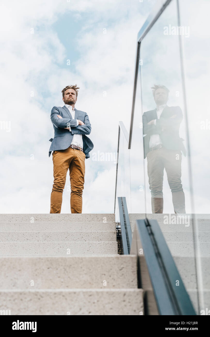Businessman standing atop of stairs Stock Photo - Alamy