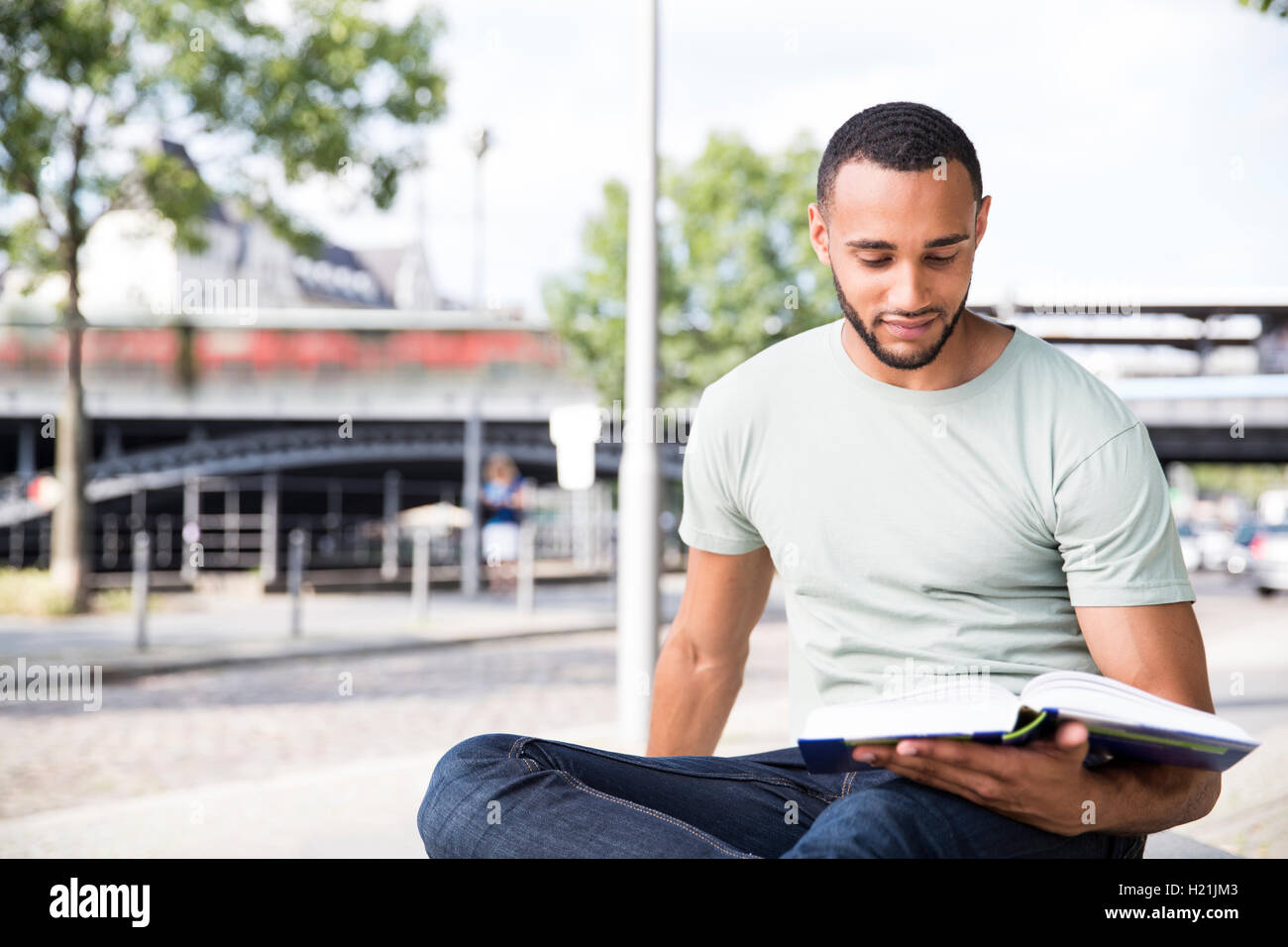 Man reading book, outdoor Stock Photo - Alamy