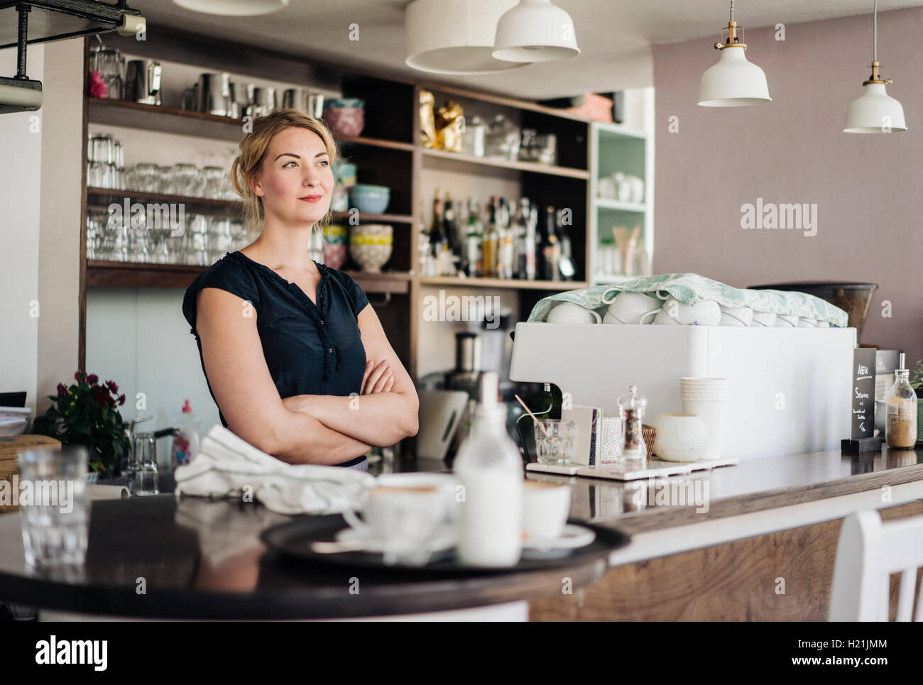 Confident woman behind counter in a cafe Stock Photo - Alamy