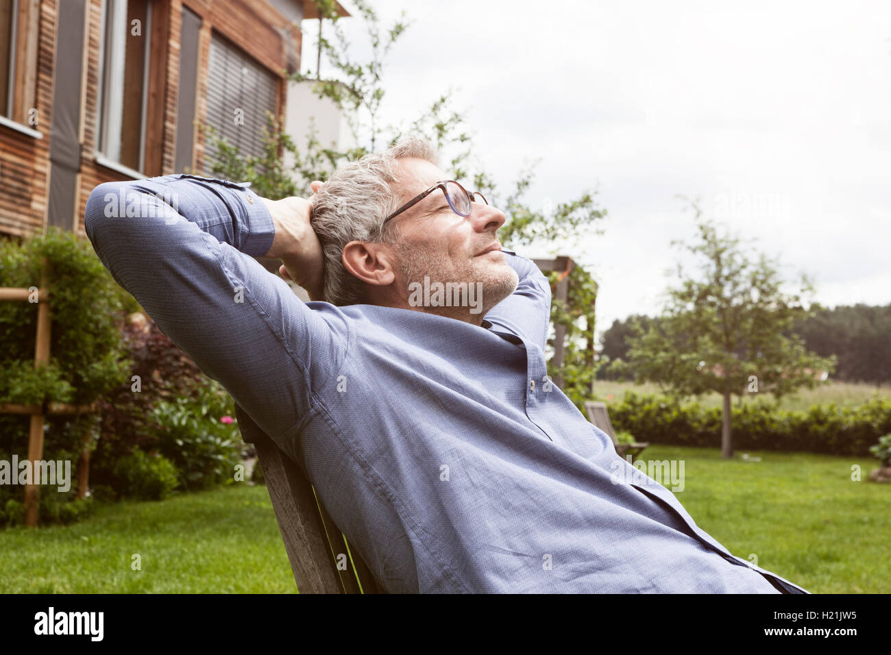 Mature man relaxing in garden Stock Photo - Alamy