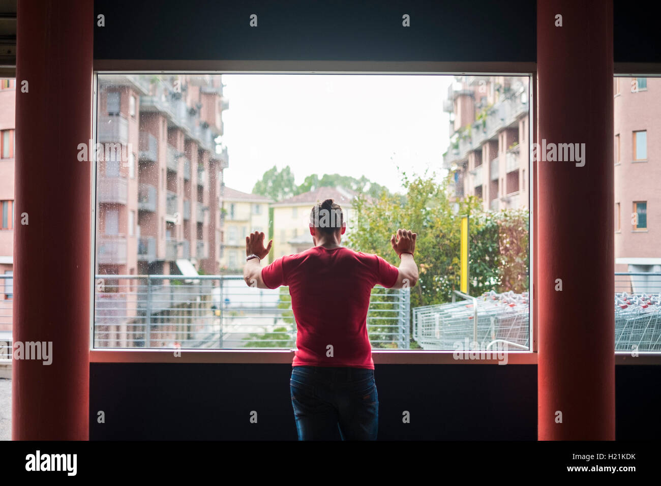 Back view of man looking through window Stock Photo - Alamy