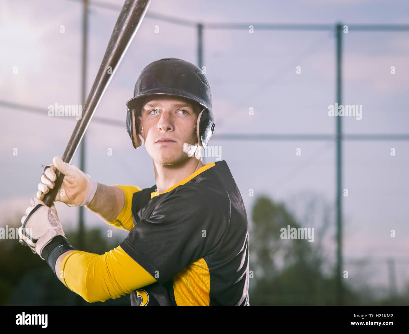 Baseball player holding bat Stock Photo - Alamy