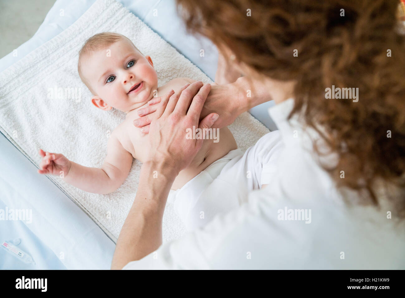 Doctor performing respiratory physiotherapy on a 6 months old baby girl ...