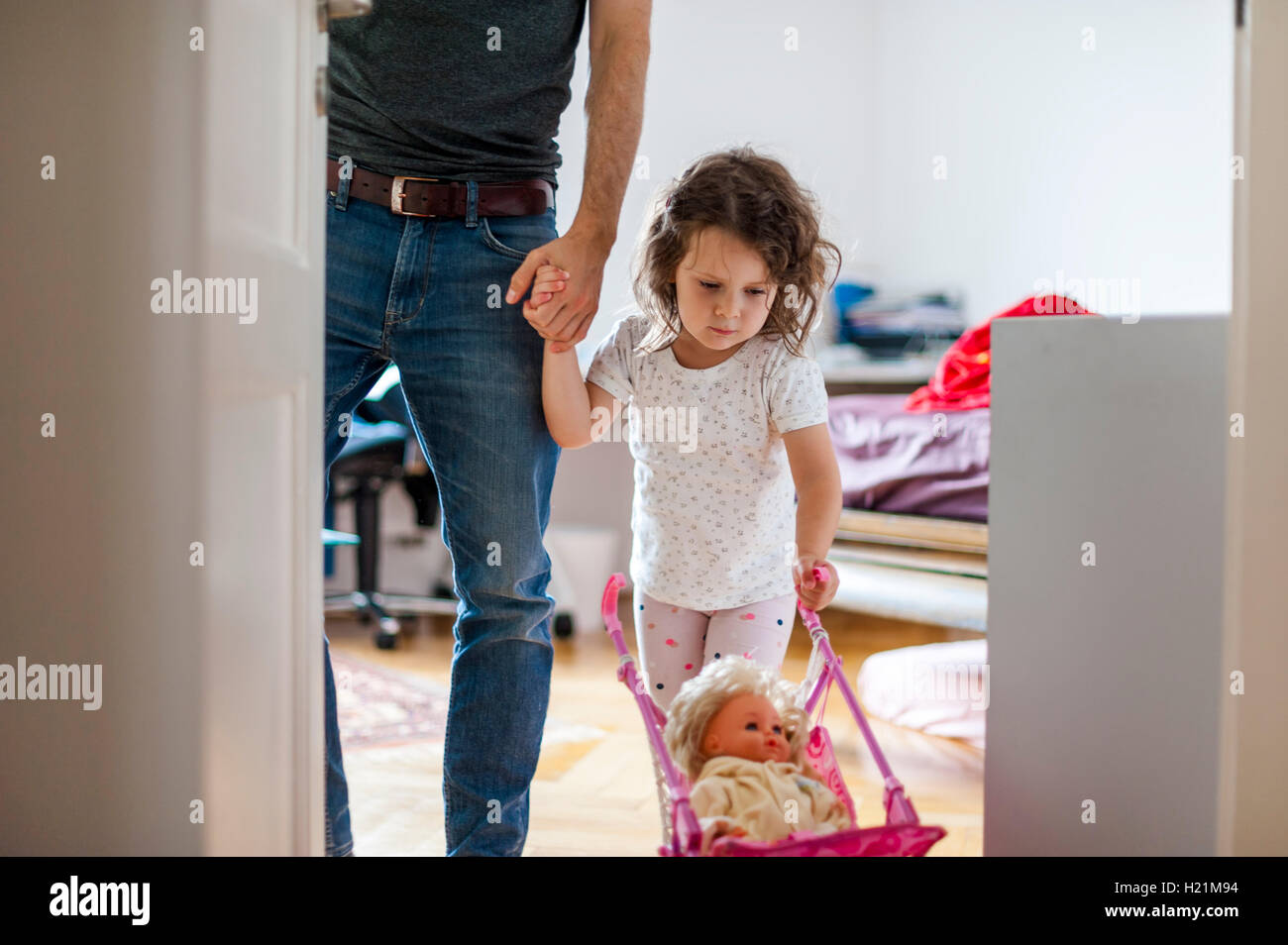 Father with daughter pushing doll buggy at home Stock Photo - Alamy