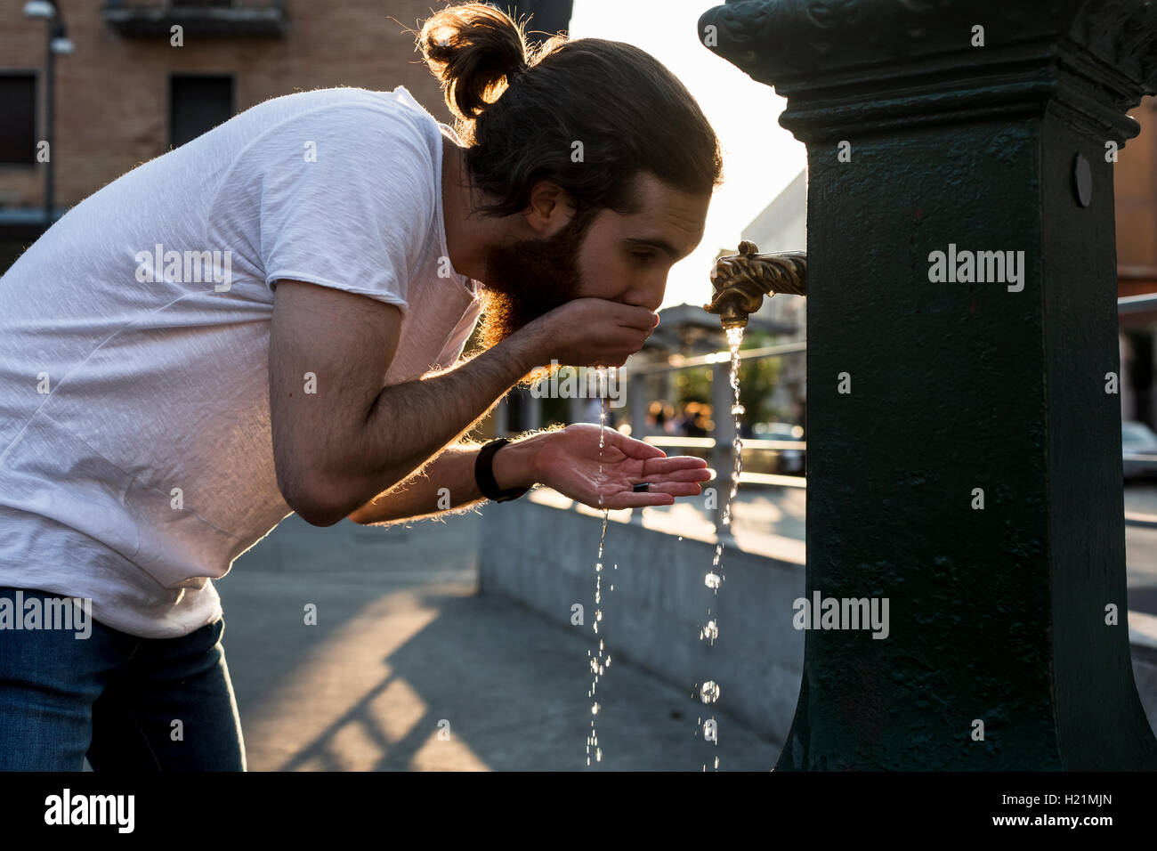 Young man drinking water in the city Stock Photo - Alamy
