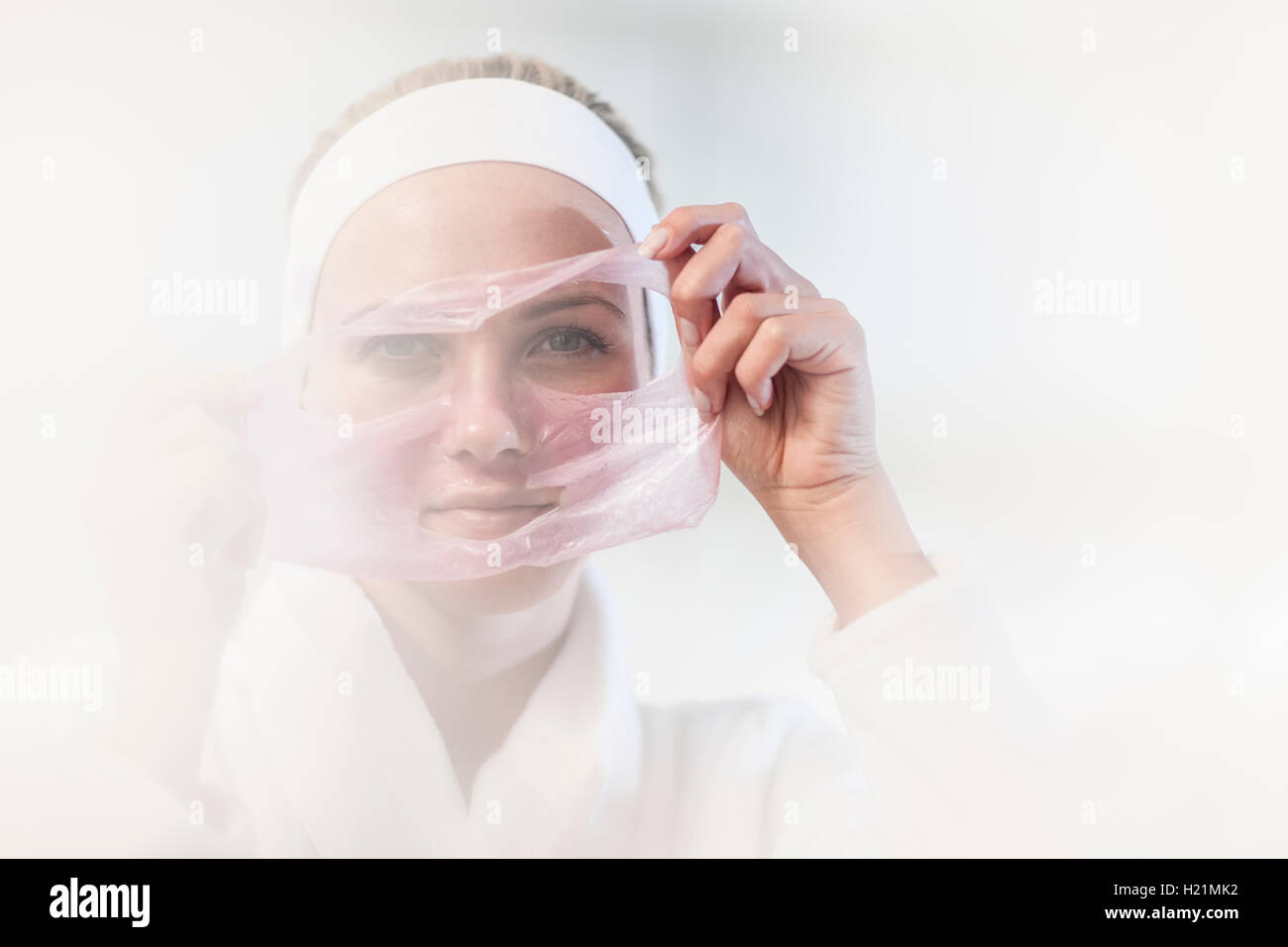 Young woman at spa removing facial mask Stock Photo - Alamy