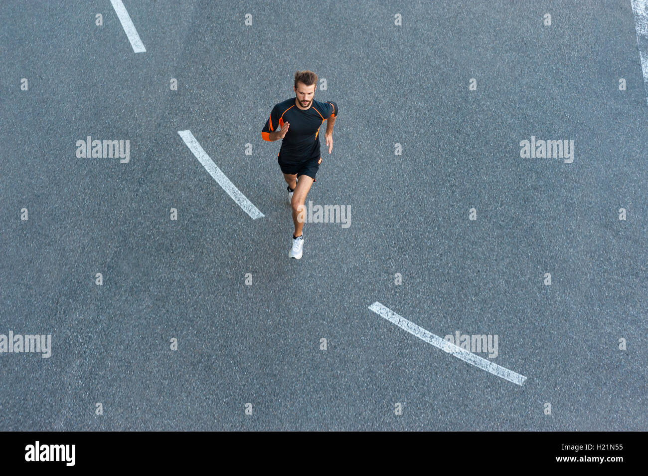 Man running on street with markings Stock Photo - Alamy