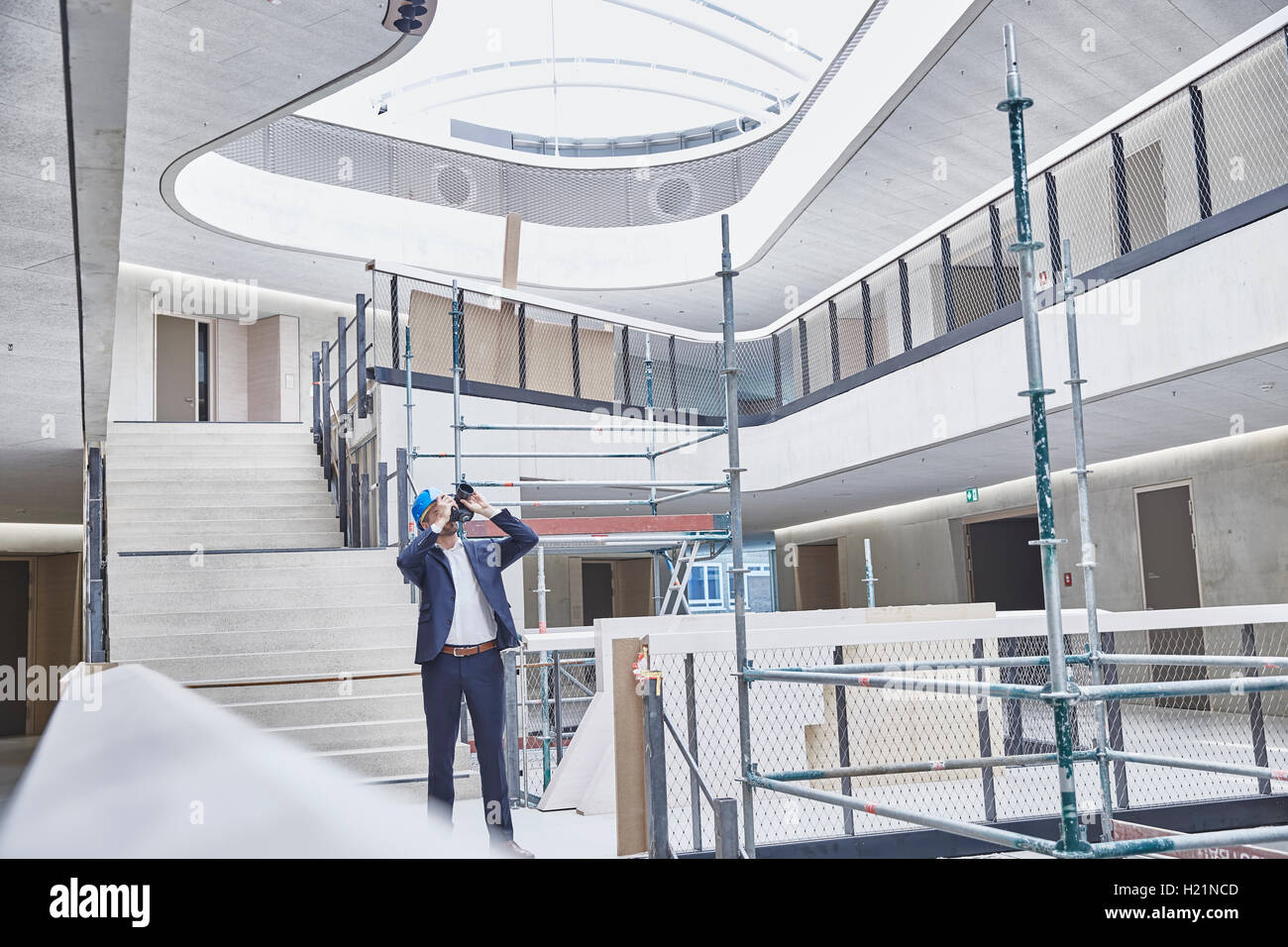 Architect on construction site of office building Stock Photo - Alamy