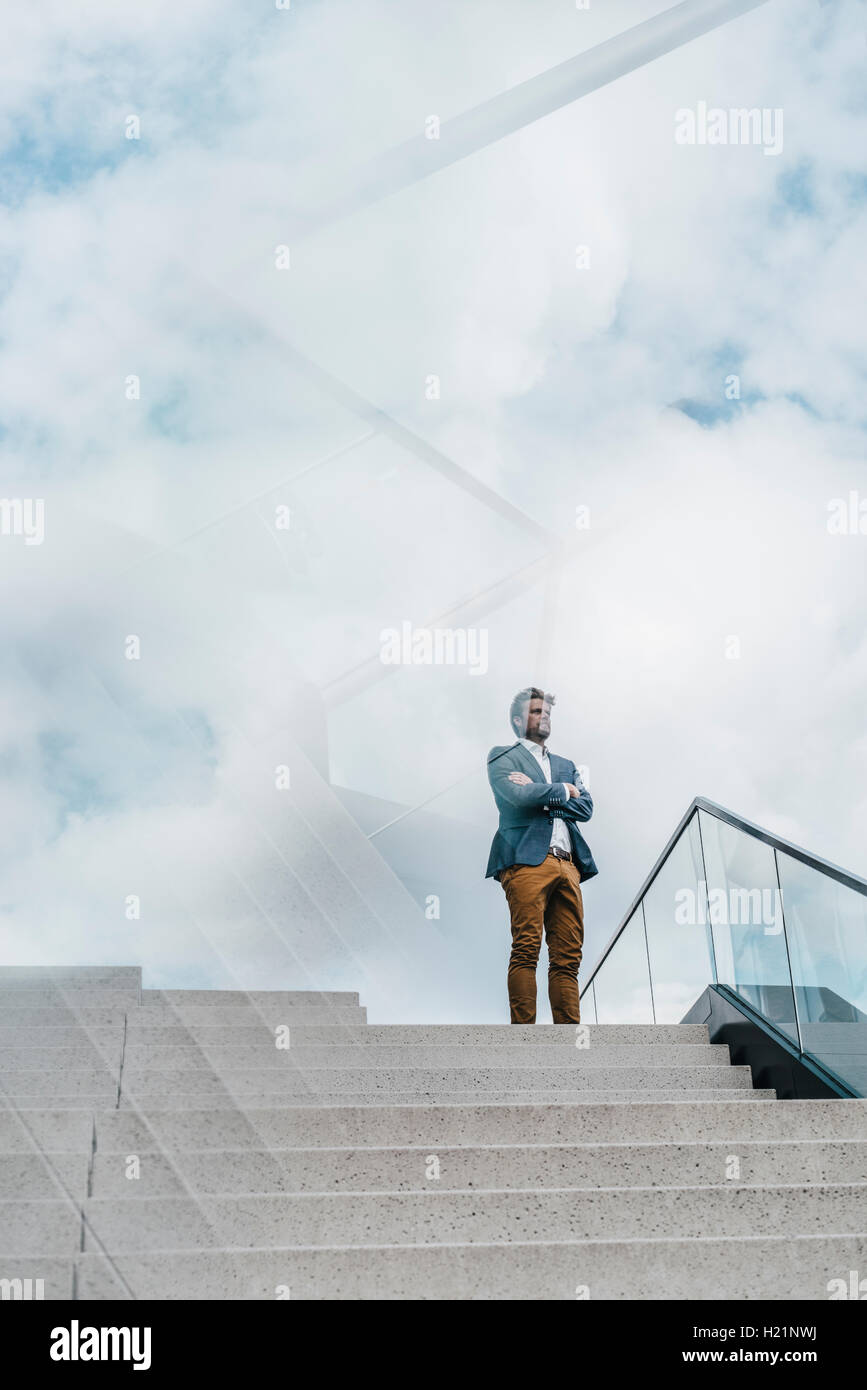 Businessman standing atop of stairs Stock Photo - Alamy