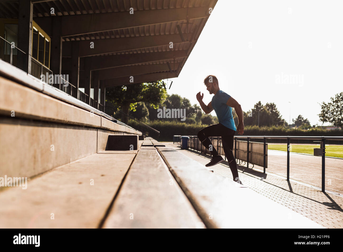 Athlete exercising on grandstand of a track and field stadium Stock ...