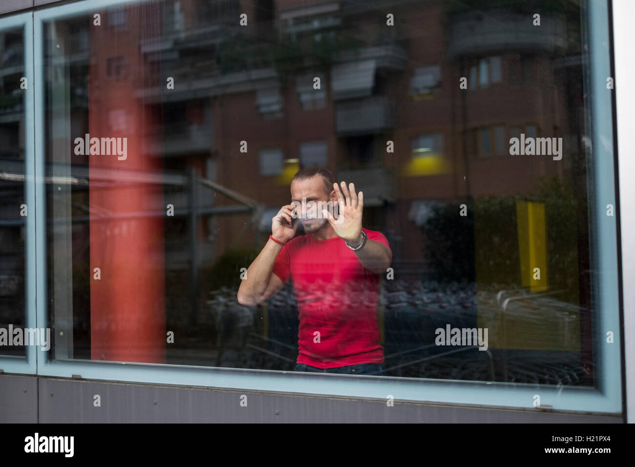 Serious man on the phone looking through window Stock Photo - Alamy