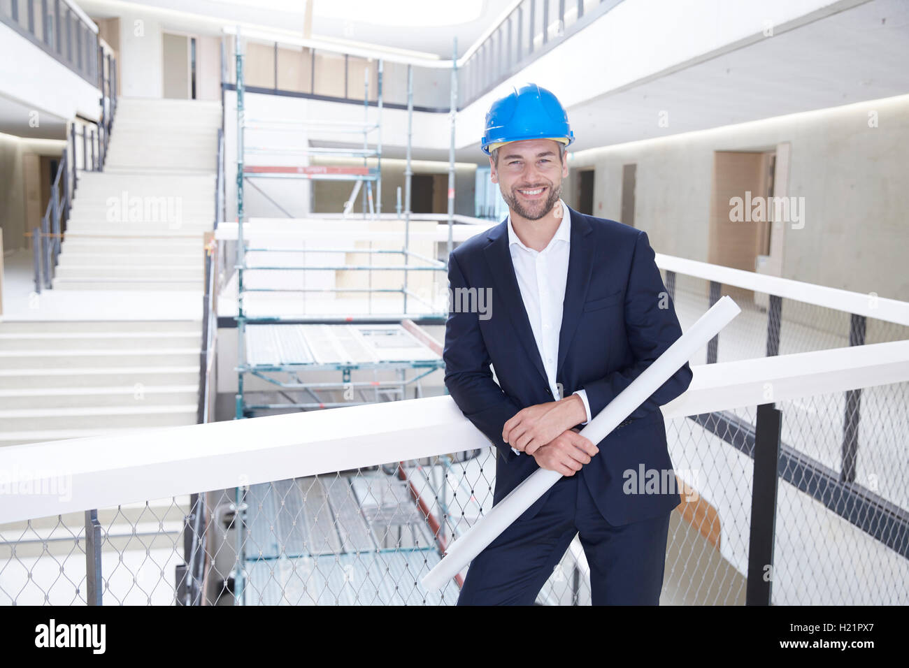 Smiling architect in office building wearing hard hat Stock Photo - Alamy