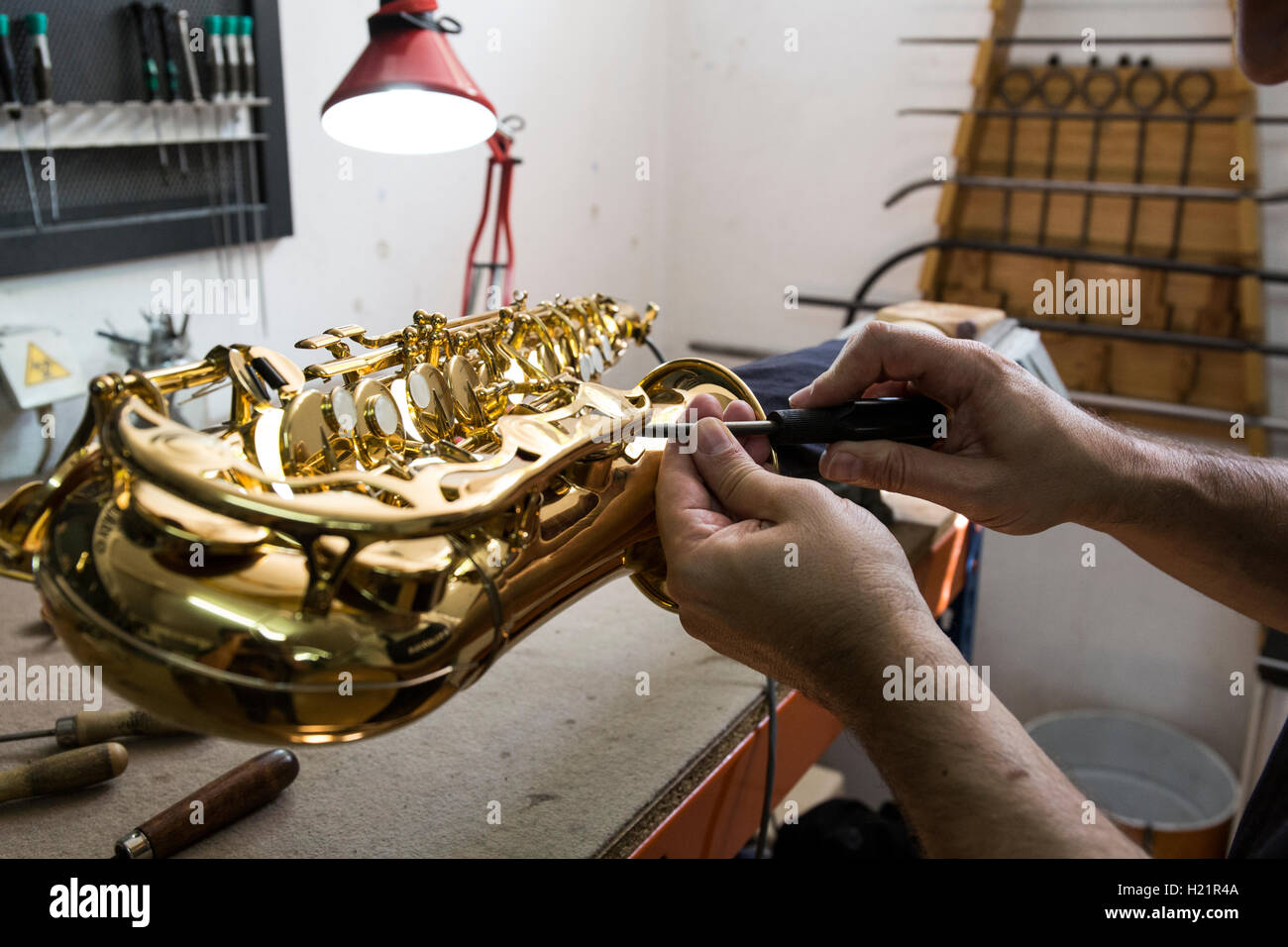 Instrument maker dismounting a saxophone during a repair Stock Photo ...