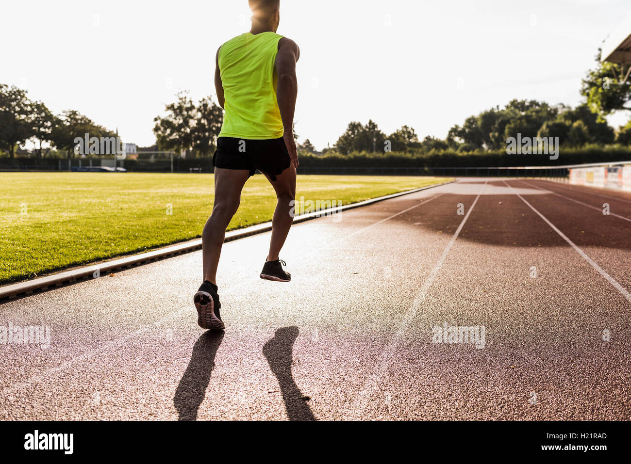 Athlete running on tartan track Stock Photo - Alamy
